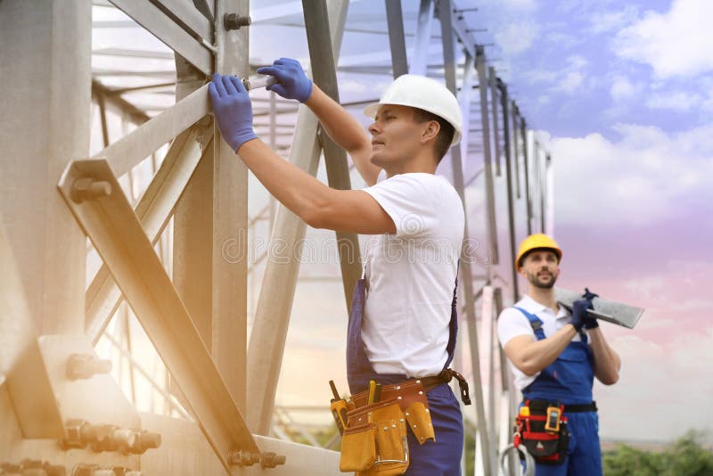 Workers Building High Voltage Tower Construction Outdoors. Installation ...