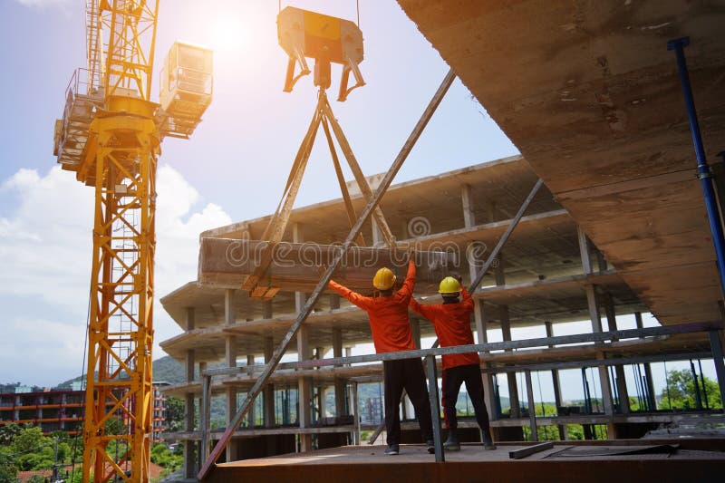 Workers at a Building Under Construction Take Slabs from a Crane Stock ...