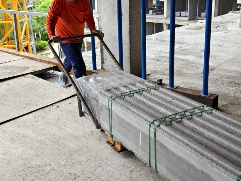 Workers at a Building Under Construction Take Slabs from a Crane Stock ...