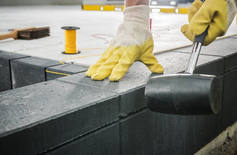 Workers Carefully Laying Concrete Blocks on a Construction Site Stock ...