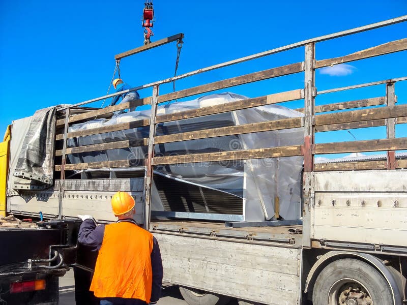 Workers are Carefully Loading Large Condenser Units Onto a Flatbed ...