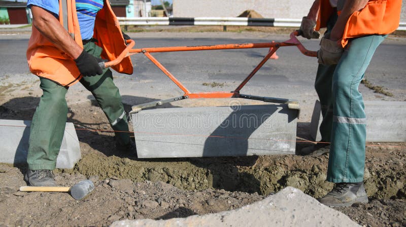 Workers Carry and Install the Curb in the Concrete. Stock Photo - Image ...