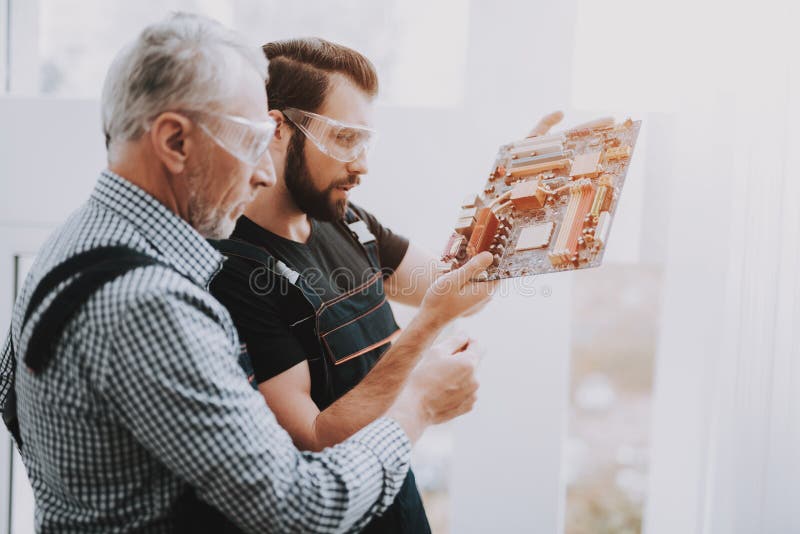 Workers Checking Device in Hands in Repair Shop. Stock Photo - Image of ...
