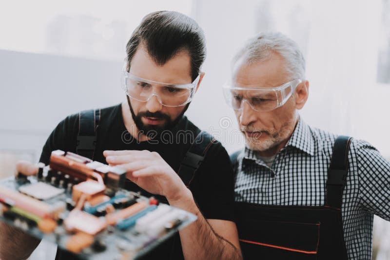 Workers Checking Device in Hands in Repair Shop. Stock Photo - Image of ...