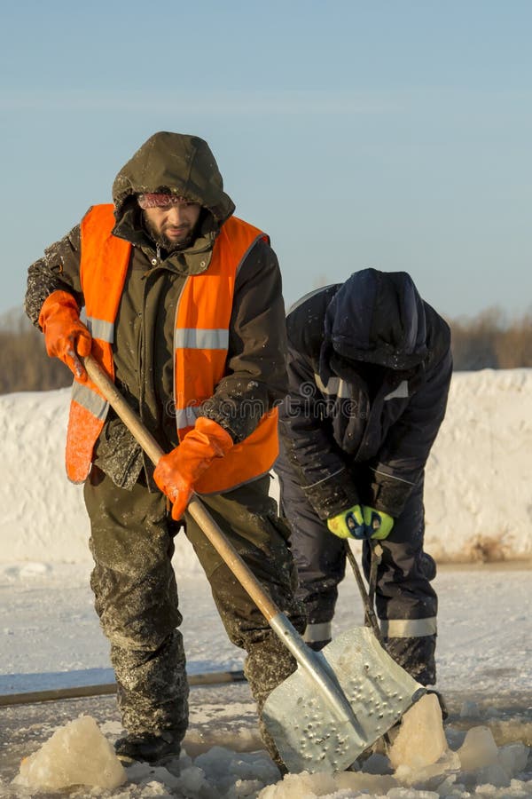 Two Workers in Overalls Remove Ice from the Hole Stock Photo - Image of ...