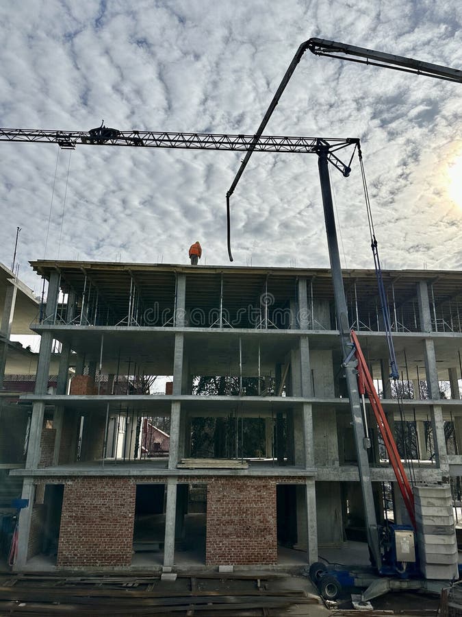 Workers at a Construction Site Against the Backdrop of the Construction ...