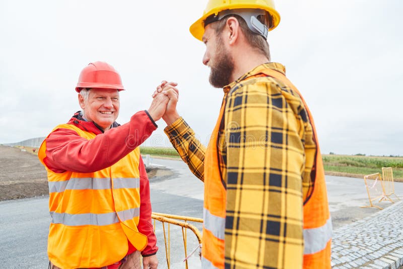 Workers on Construction Site Celebrate Success with Handshake Stock ...