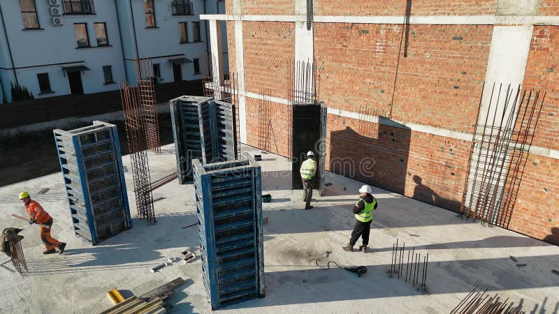 Workers at Construction Site with Steel Frames and Brick Walls ...