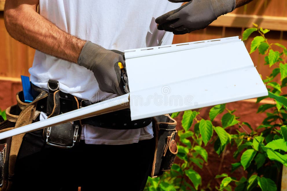 Workers Cut Plastic Vinyl Siding To Size Using Scissors Prior To a ...