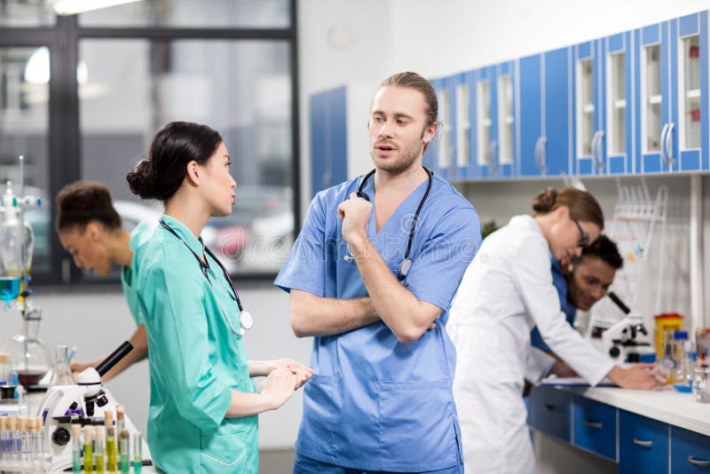 Workers Discussing Work with Colleagues Behind in Laboratory Stock ...