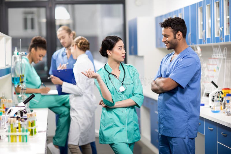 Workers Discussing Work with Colleagues Behind in Laboratory Stock ...