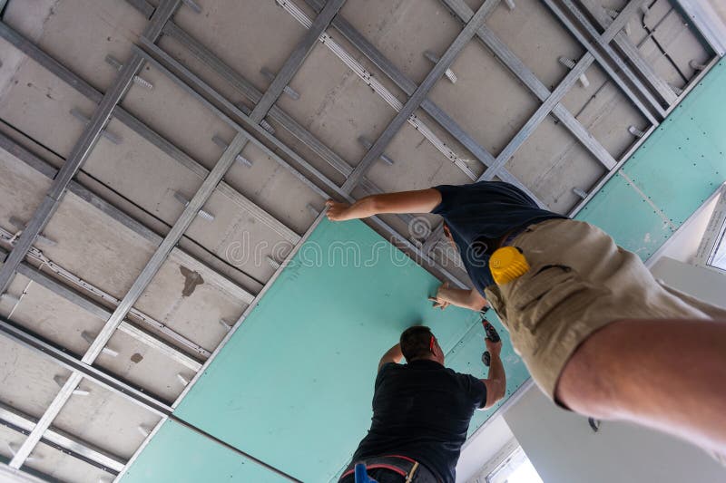 Workers Fitting Panel into Frame of Ceiling. Stock Photo - Image of ...