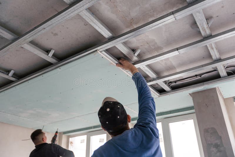 Workers Fitting Panel into Frame of Ceiling. Stock Image - Image of ...