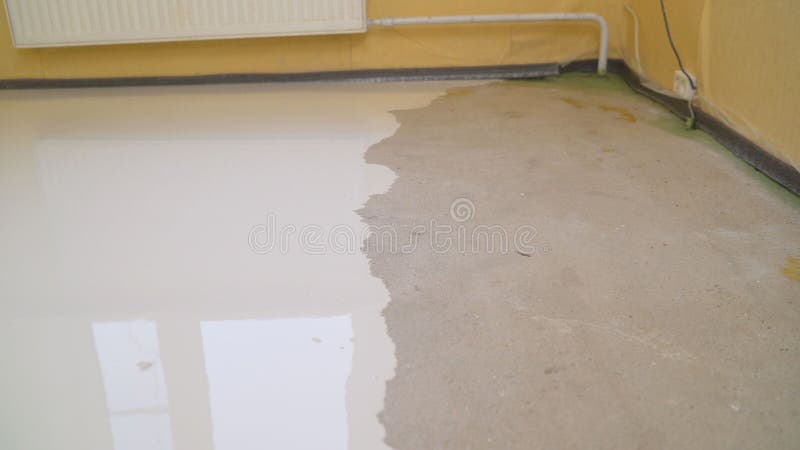 Workers Flood the Floor. Liquid Flooring. Leveling the Floor with a ...