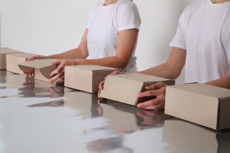 Workers Folding Cardboard Boxes at Table, Closeup. Production Line ...