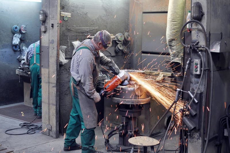 Worker with a Grinding Machine Processes a Gear Wheel - Production of ...