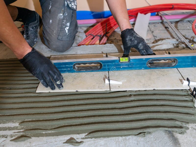 Workers Hands with Ceramic Tiles and Tools for Tiler. Floor Tiles ...