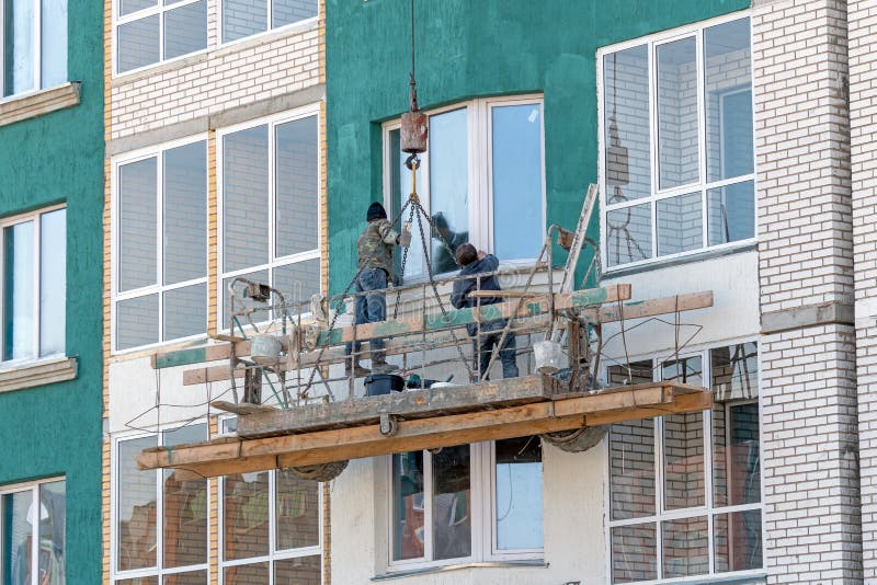 Workers in a Hanging Cradle Repair the Facade of a Building Stock Photo ...
