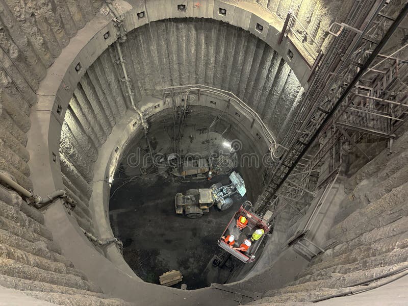 Workers in Helmets Descend into the Mine Shaft Using a Construction ...