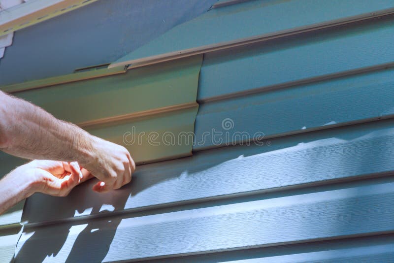 Workers Install Vinyl Plastic Siding Panels on Wall Facade of a New ...