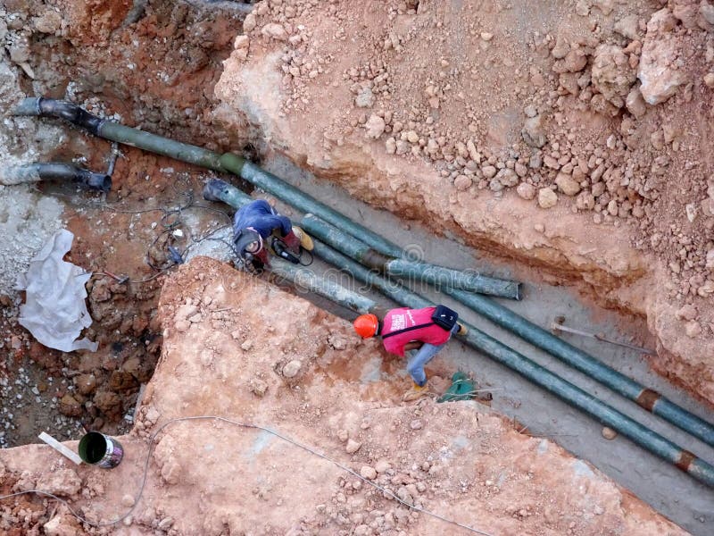 Workers Installing Underground Utility and Services Pipe in the Shallow ...
