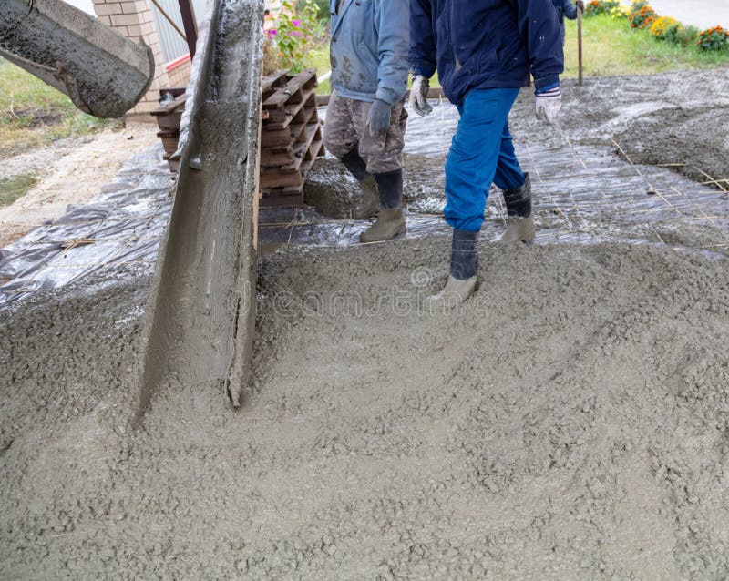 Workers Level Out the Concrete Mix at a Construction Site. Stock Photo ...