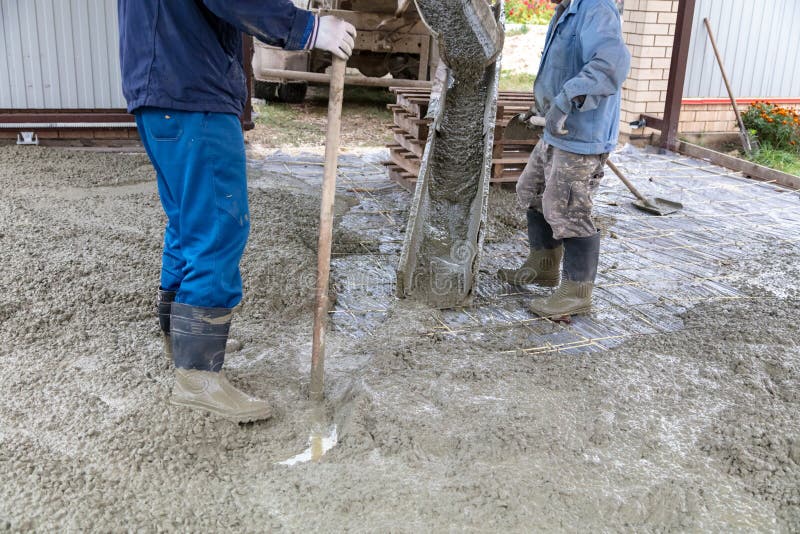 Workers Level Out the Concrete Mix at a Construction Site. Stock Image ...