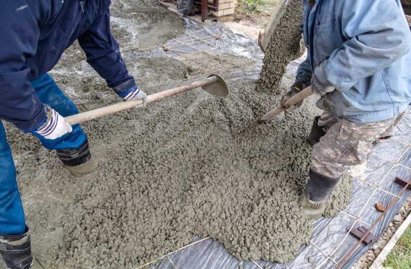 Workers Level Out the Concrete Mix at a Construction Site. Stock Image ...