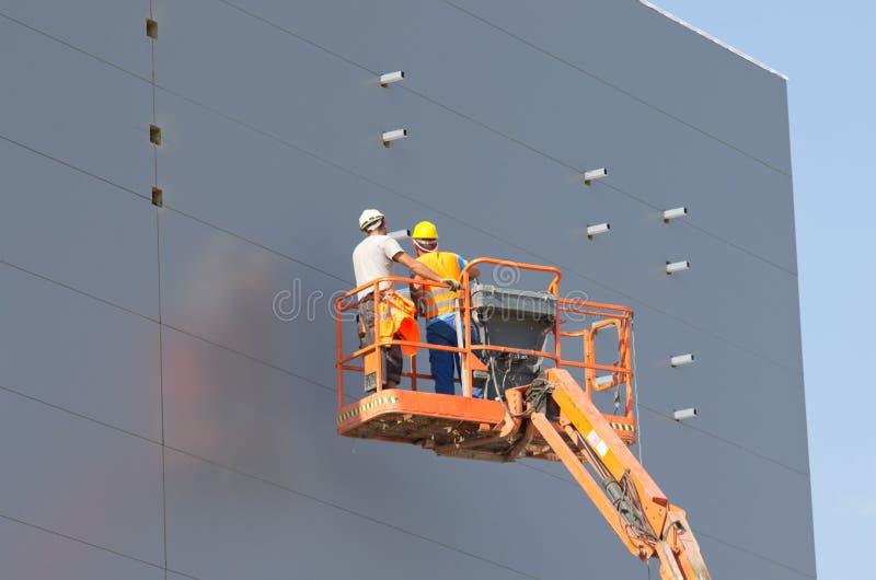 Workers in lifting cage stock photo. Image of project - 58206316