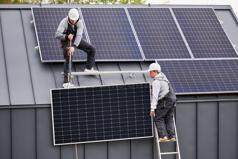 Workers Lifting Up Photovoltaic Solar Module while Installing Solar ...
