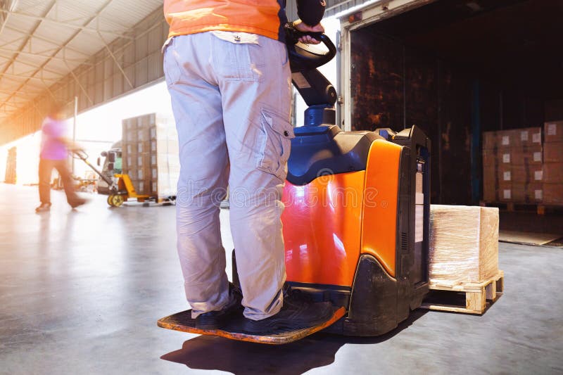 Workers Loading Pallets of Goods into the Truck. Forklift Pallet Jack ...
