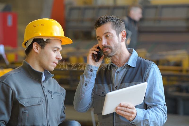 Workers Looking at Digital Tablet in Warehouse Stock Photo - Image of ...