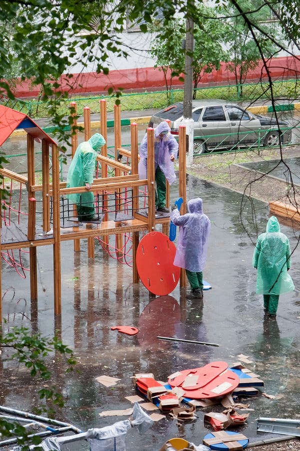 Workers in Multi-colored Rain Capes Work on the Playground. Editorial ...