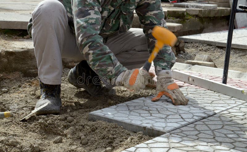 Workers paving walkway stock photo. Image of gloves, bricklayer - 67368262