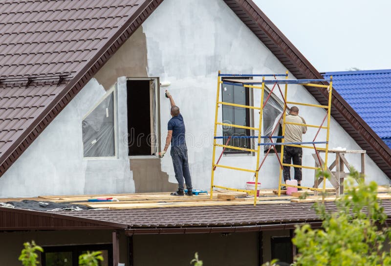 Workers are Priming Outside the Walls of the House. Stock Image - Image ...