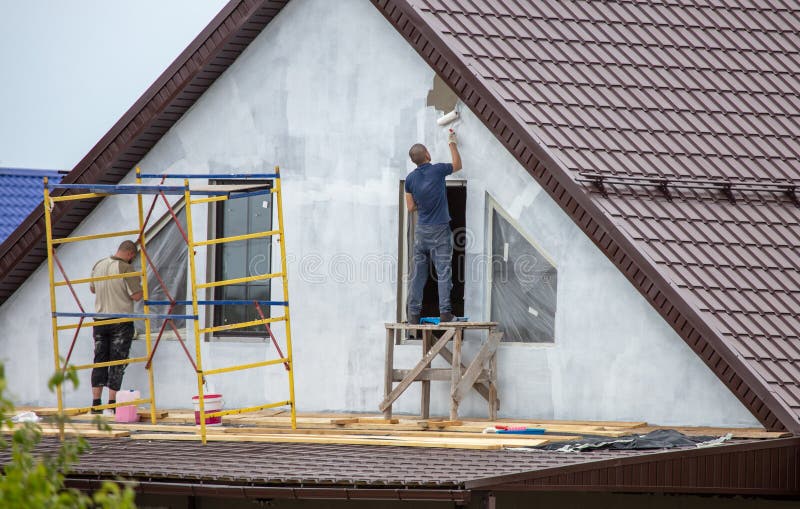 Workers are Priming Outside the Walls of the House. Stock Image - Image ...