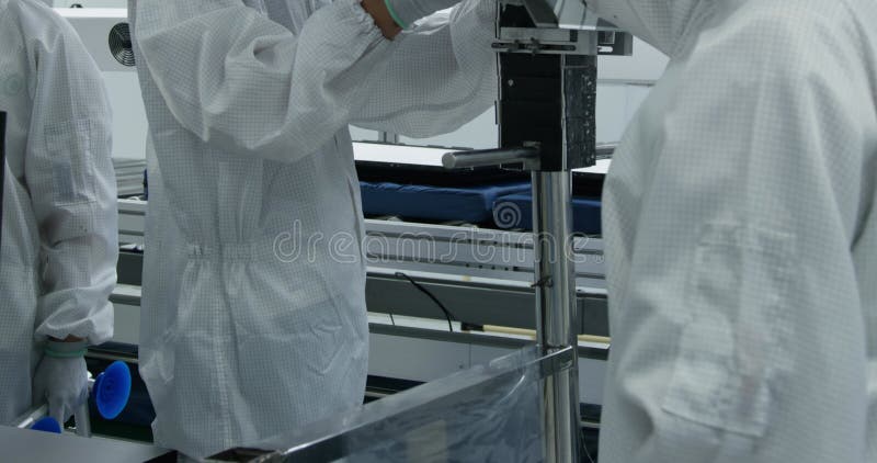 Workers in Protective Gowns, Gloves and Masks Work on a Conveyor Belt ...