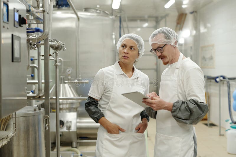 Workers Reviewing Brewing Process Equipment in Distillery Stock Photo ...