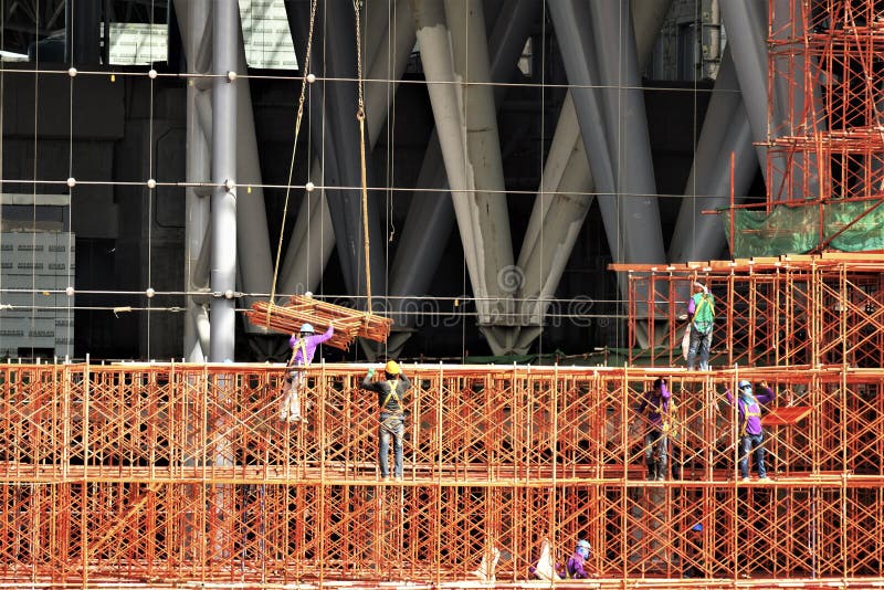 Workers on the Scraffold Working at Height of Building Under ...