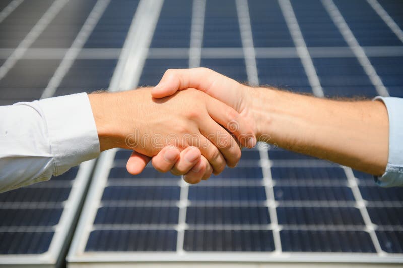 Workers Shaking Hands on a Background of Solar Panels on Solar Power ...
