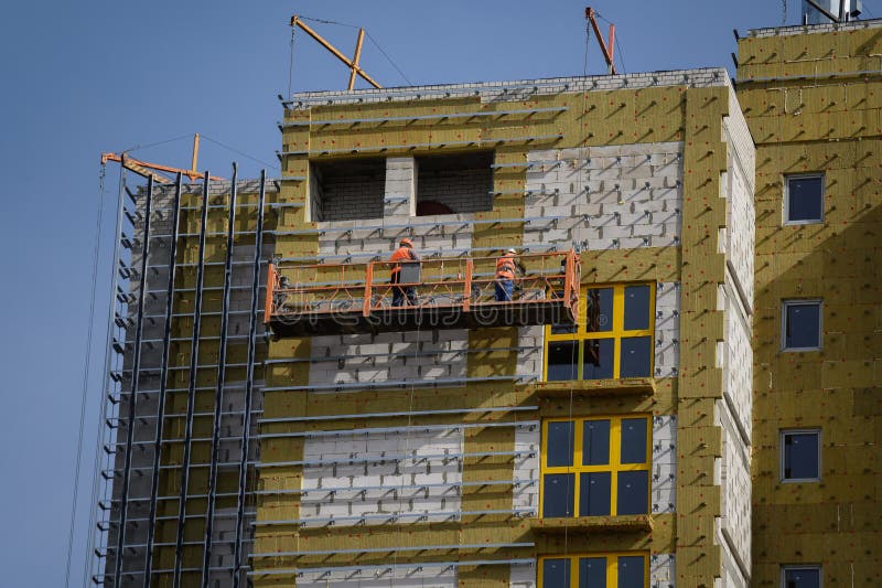 Workers Sheathe the Outer Walls of the Building with Insulation ...
