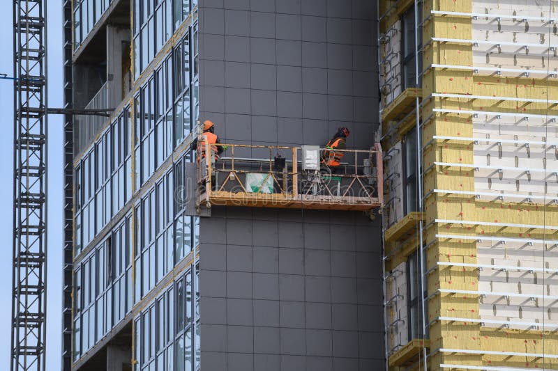 Workers Sheathe the Outer Walls of a Brick House with Insulation ...