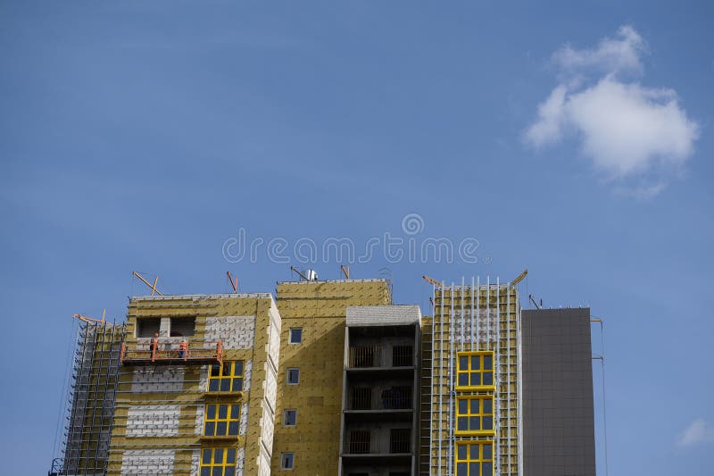 Workers Sheathe the Outer Walls of the Building with Insulation ...