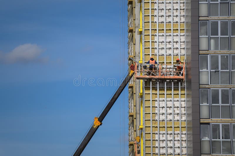 Workers Sheathe the Outer Walls of the House with Insulation ...