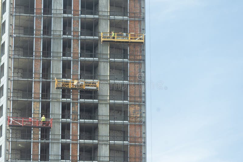 Workers Sheathe the Outer Walls of a Brick House with Insulation ...