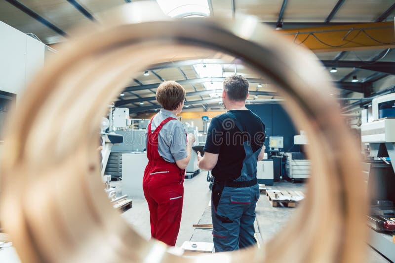 Workers Standing on the Factory Floor Seen through a Workpiece Stock ...