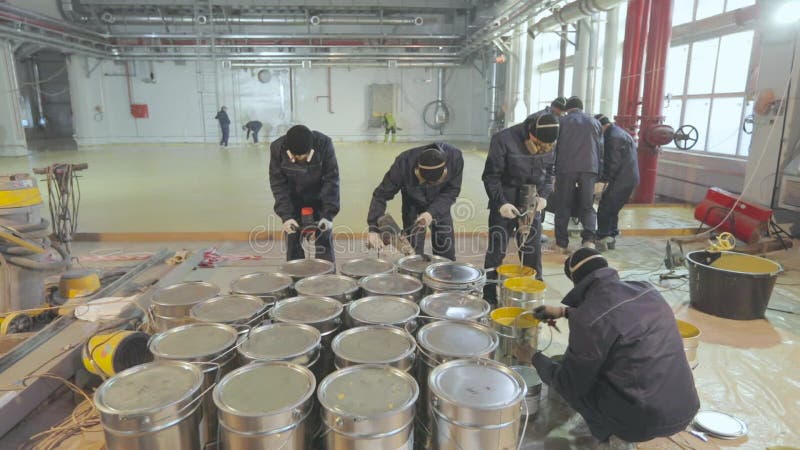 Workers Stir Up the Bulk Floor in the Barrel. Workers at a Construction ...