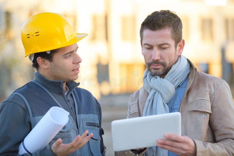 Two Workers Talking while Holding Papers and Ruler Stock Image - Image ...