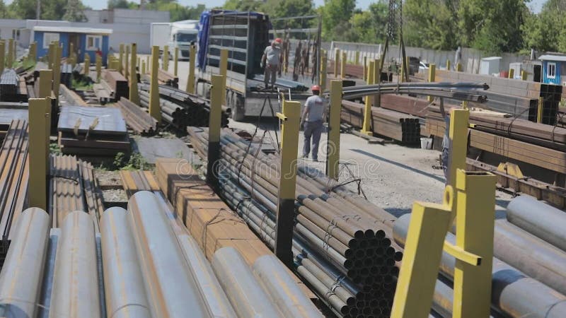 The Working Process in a Warehouse with a Metal. Workers Unload a Metal ...