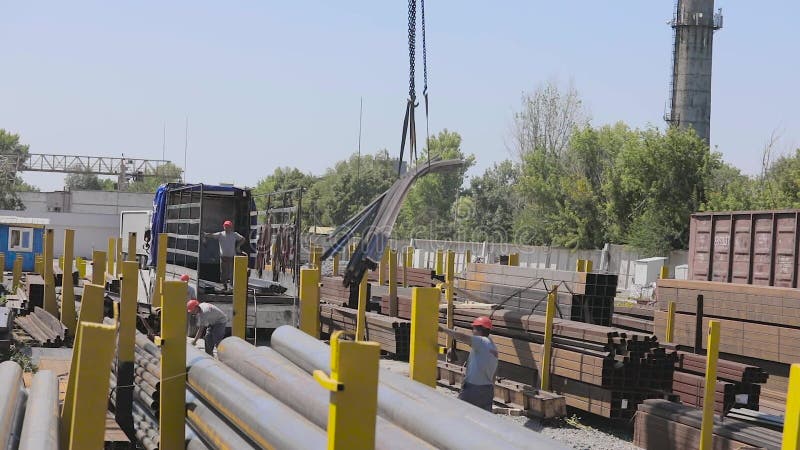 The Working Process in a Warehouse with a Metal. Workers Unload a Metal ...